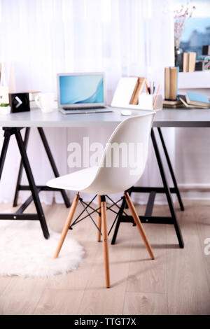 Workplace with laptop, table and chair beside the window Stock Photo ...
