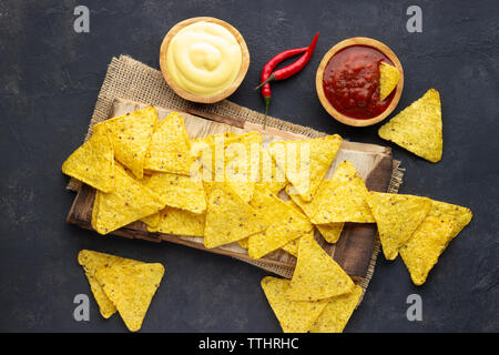 Tasty nachos and sauces on dark background Stock Photo - Alamy