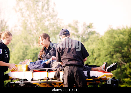 Paramedics pushing a patient on a gurney from an ambulance Stock Photo ...