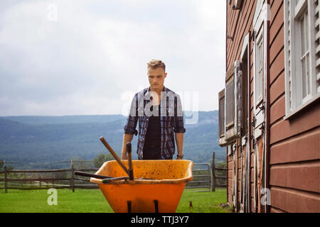 Man pushing a wheelbarrow Stock Photo - Alamy