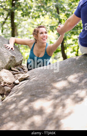 A young man sitting on a boulder looking at Weller Lake, surrounded ...