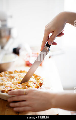 cropped image of woman cutting pie on table while friends sitting Stock ...