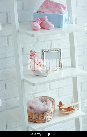 Baby toys and clothes on brick wall background Stock Photo - Alamy