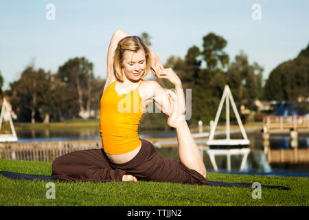 Woman practicing yoga, Mermaid pose, doing Eka Pada Rajakapotasana ...