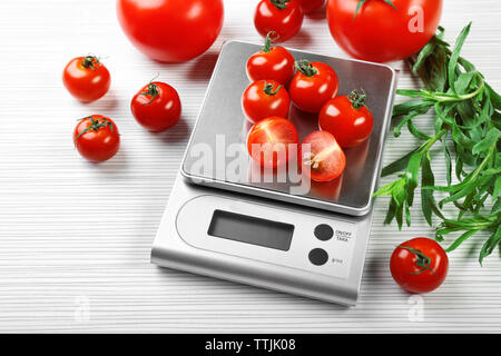 Tomatoes and tarragon with digital kitchen scales on wooden background ...
