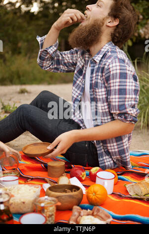 Friends having breakfast while sitting by picnic table in forest Stock ...