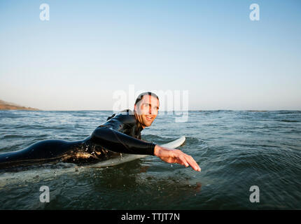 Man surfboarding in sea against sky Stock Photo - Alamy