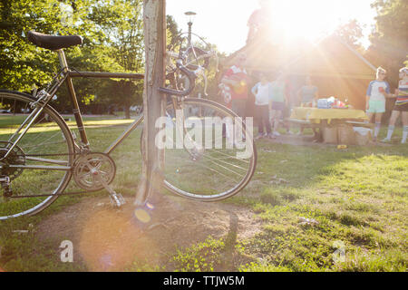 Bicycle parked on grassy field near wooden fencing against gray ...