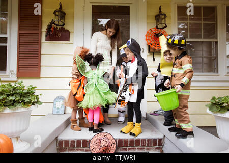 girls in halloween costumes with candies at home Stock Photo - Alamy