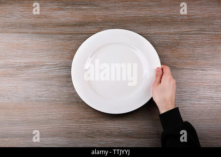 Man holding empty plate. Hunger concept Stock Photo - Alamy