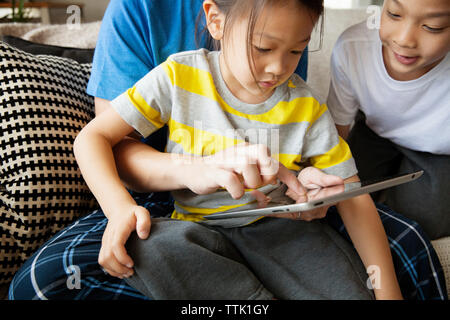 Midsection of man touching son sitting on baby carriage at public park ...