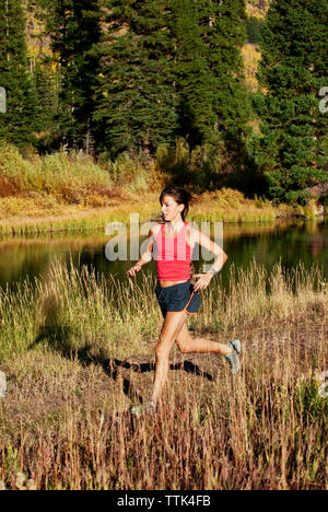 Woman jogging on lakeshore Stock Photo - Alamy