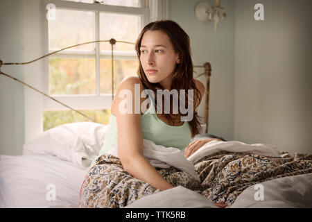 Young woman waking up on bed Stock Photo - Alamy