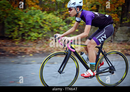 Asian male cyclist riding road bicycle, side view isolated on white ...