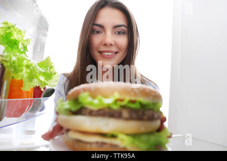 Young beautiful woman looking into fridge at night Stock Photo - Alamy
