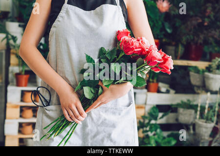 Midsection of florist holding roses in shop Stock Photo - Alamy