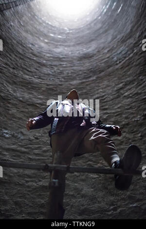 Low angle view of male fashion model in eyeglasses adjusting bow tie ...