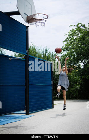 Girl playing basketball. Player throwing ball. Outdoor sports field in ...
