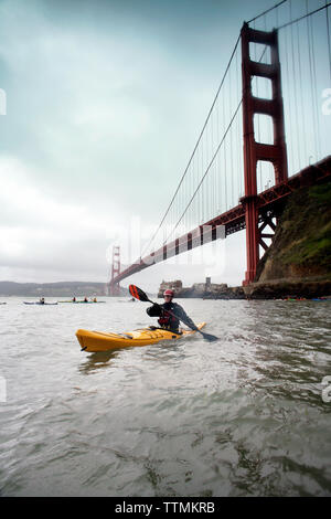 USA, California, San Francisco, individuals endure the cold to kayak ...