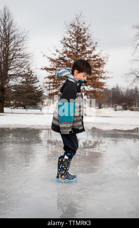 Child splashing in icy puddle Stock Photo - Alamy
