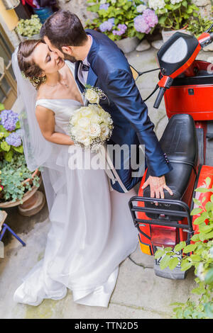 High angle side view of romantic newlywed couple standing face to face ...