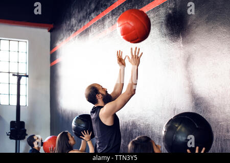 Throwing medicine balls four adults performing synchronized moves in ...