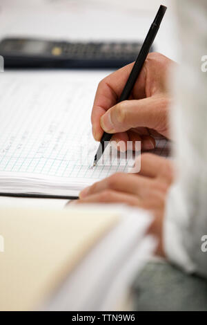 Hands of a scientist writing notes about a research sample, holding a ...