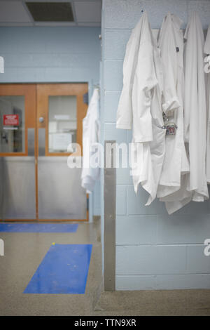 Laboratory coats hanging from a door Stock Photo - Alamy