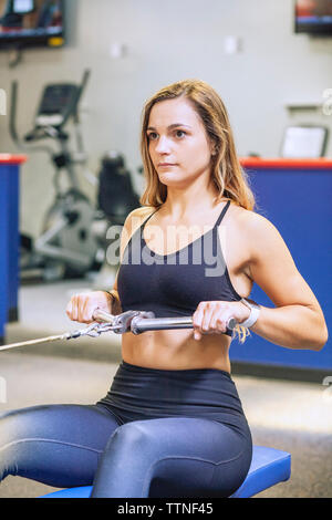 Cute young blond woman working out in fitness gym isolated over white ...