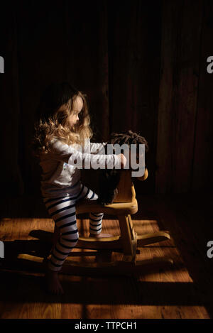 Girl sitting on a rocking horse Stock Photo - Alamy