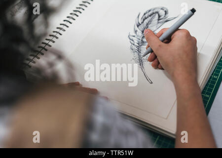 Artisan hands drawing design on wood plank using pencil and template ...