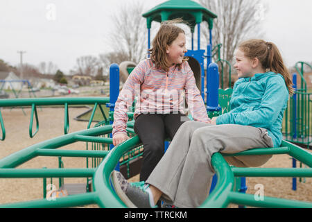 Friends at playground talking Stock Photo - Alamy