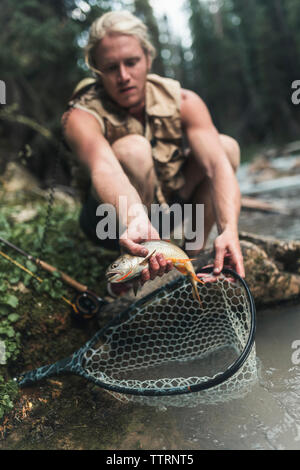 Young man holding fish catch on fishing boat, Oamaru, Otago Region ...