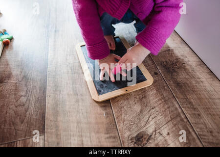 Low section of girl crouching on chair at home Stock Photo - Alamy