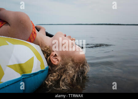 Girl lying on raft Stock Photo - Alamy