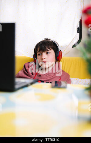 Teen boy sitting with laptop on isolated white background Stock Photo ...