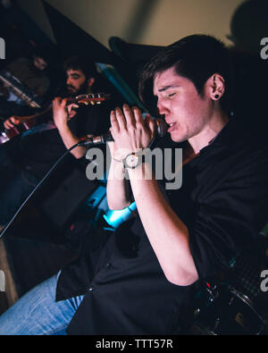 Man singing while coworker playing guitar in nightclub Stock Photo - Alamy