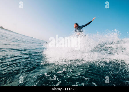 A surfer takes off on a wave under a blackened sky from the Palisades ...