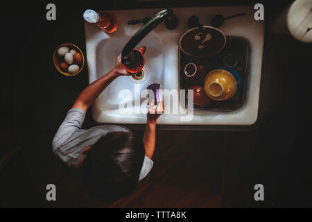 Teenage boy washing dishes in a kitchen Stock Photo - Alamy