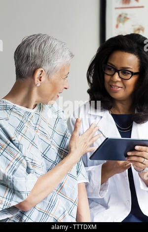 Doctor discussing medical report with mature patient. Smiling male ...