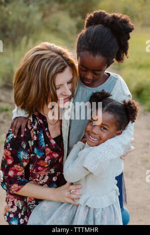 high angle view of curly mother in loungewear taking baby daughter in ...