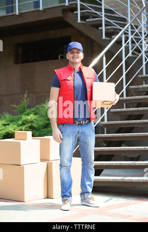 Young male deliverer with boxes outdoors Stock Photo - Alamy