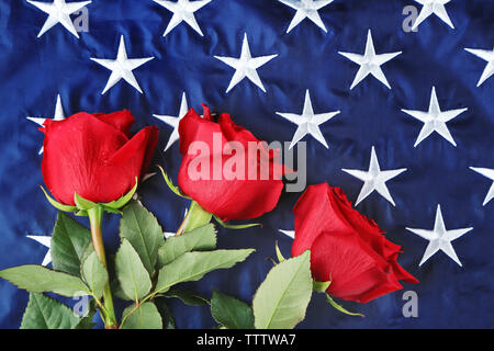 Red roses on American flag with military backpack, closeup Stock Photo ...