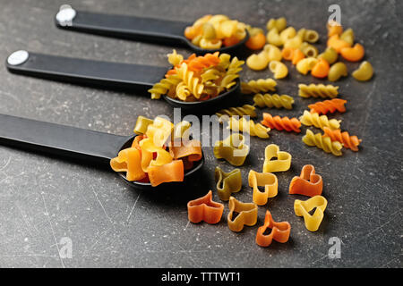 Different dry pasta on measuring spoons Stock Photo - Alamy