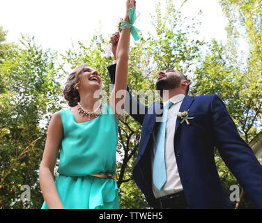 Beautiful bridesmaid with handsome groomsman in the studio hugging ...