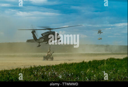 U.S. Army Soldiers attach a M119A3 Howitzer to a UH-60 Black Hawk ...