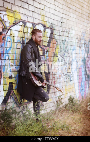 Young caucasian male graffiti artist drawing big street art painting in ...