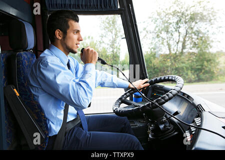 Handsome driver using microphone in bus Stock Photo - Alamy