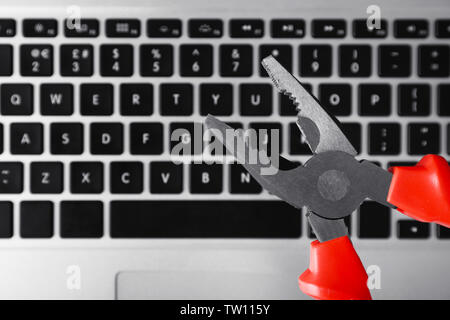 Pliers on laptop keyboard background Stock Photo - Alamy
