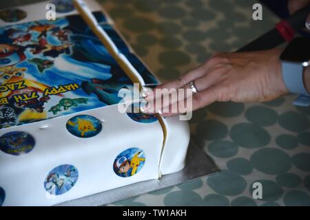 Woman wearing Apple Watch cutting children birthday cake with avengers ...